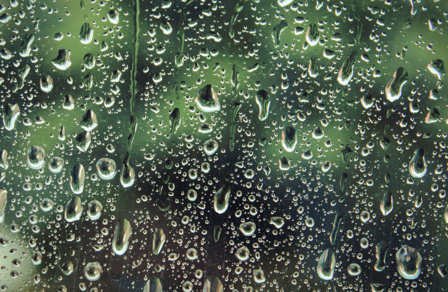 Dripping down drops of rain on glass - H Window